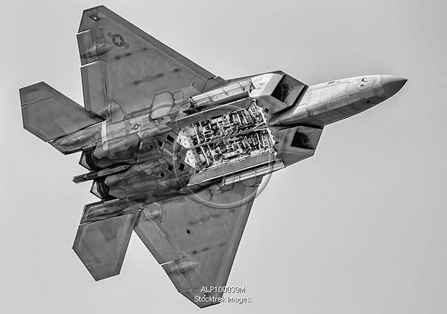 High contrast black and white image of a F-22 Raptor in flight with ...