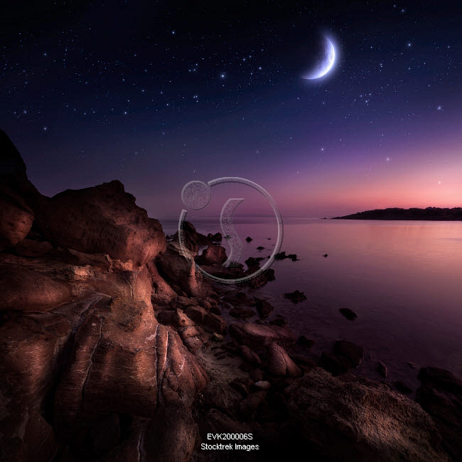 Rising moon over ocean and mountains against starry sky. | Stocktrek Images