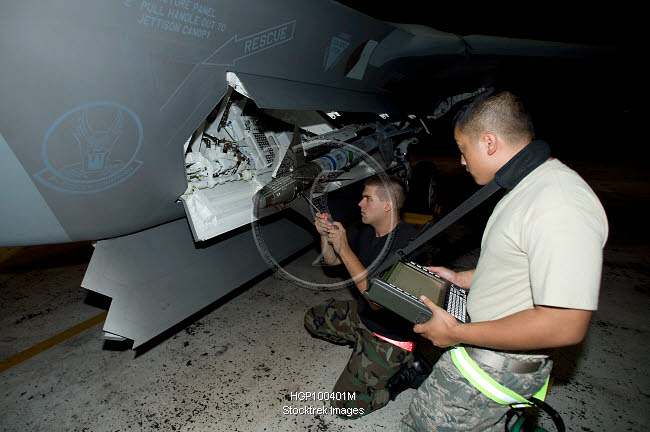 Maintence crew works on an F-22 Raptor. | Stocktrek Images