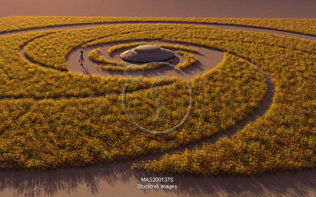 A flying saucer and a grey alien in a crop circle. | Stocktrek Images