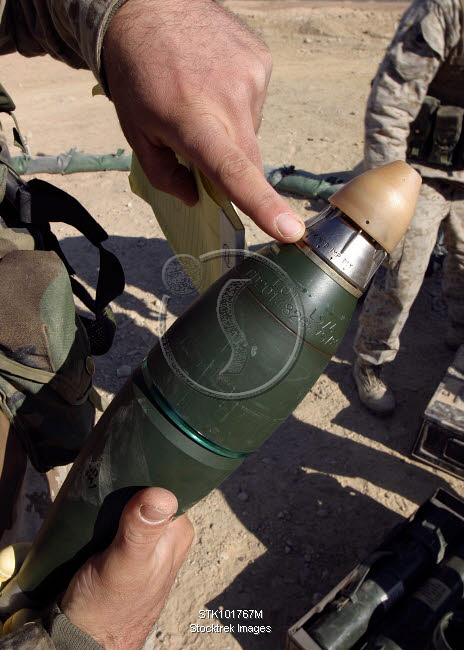 A squad leader points to a delay setting on an 81mm mortar round ...
