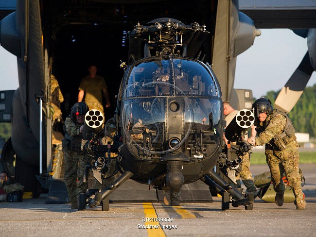 Men unloading an AH-6 Little Bird attack helicopter at Saber Army ...